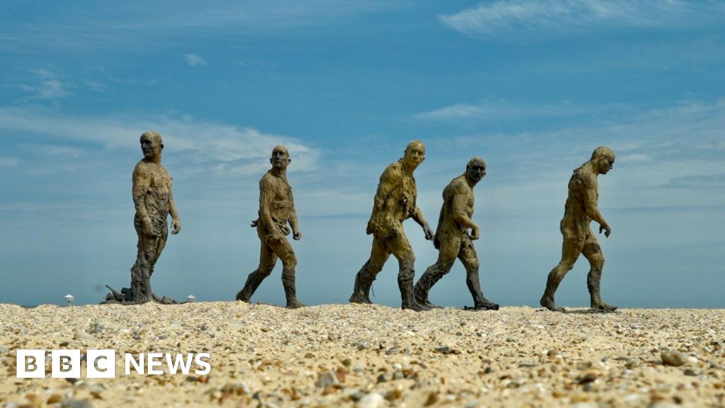 Lowestoft beach welcomes giant sculpture of five walking men - BBC News