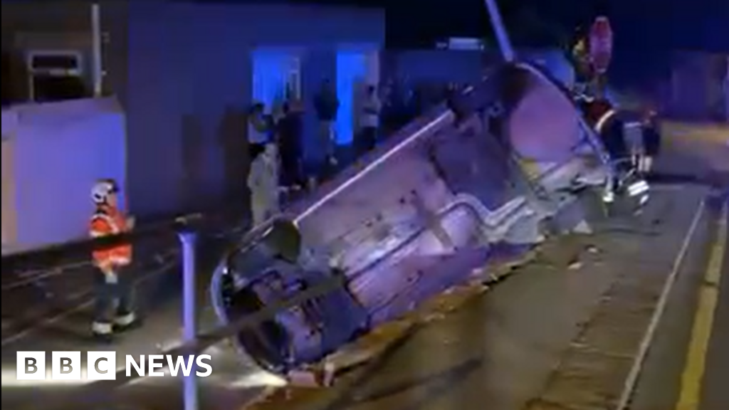 Crash leaves car dangling over Jersey railing