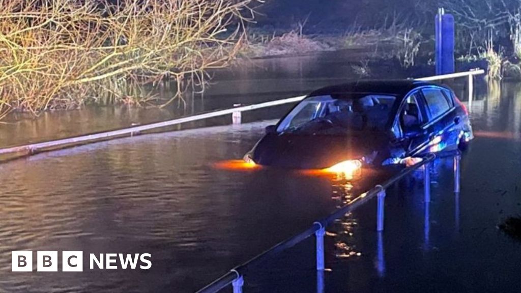 Woman rescued from car trapped in Essex flood water - BBC News