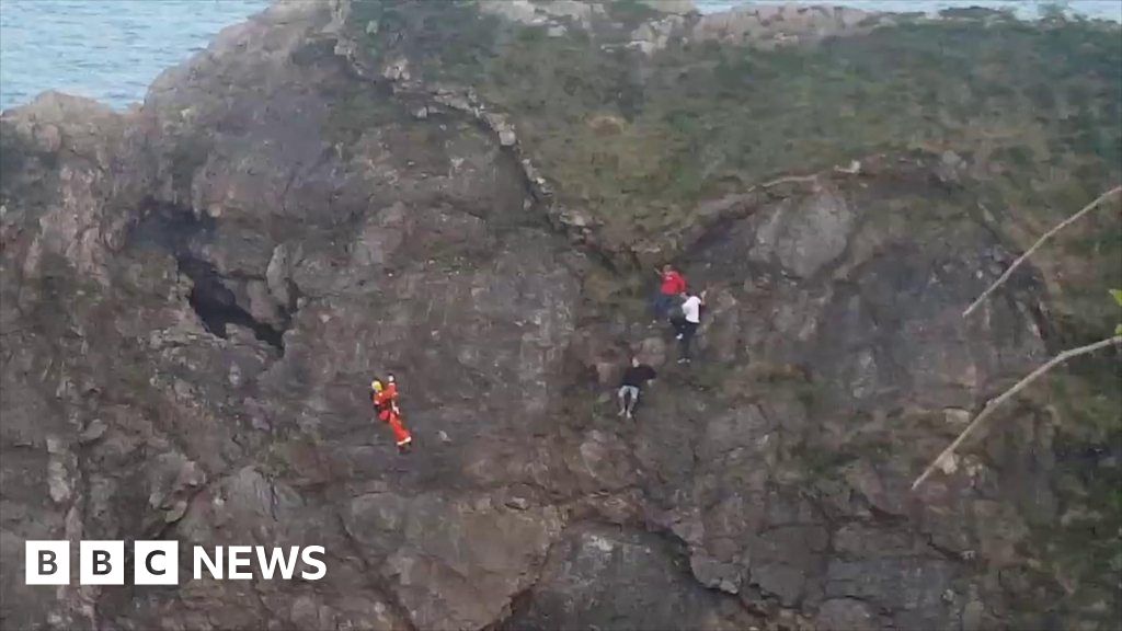 Dorset cliff rescue: Video shows three people plucked to safety - BBC News
