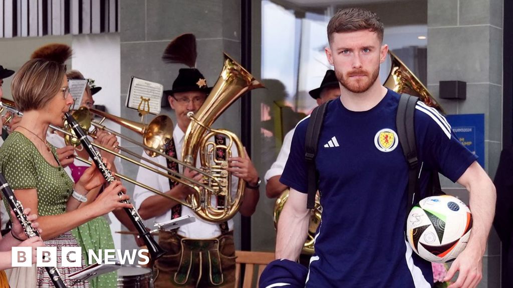 Dejected Scotland squad gets jolly farewell from oompah band - BBC News