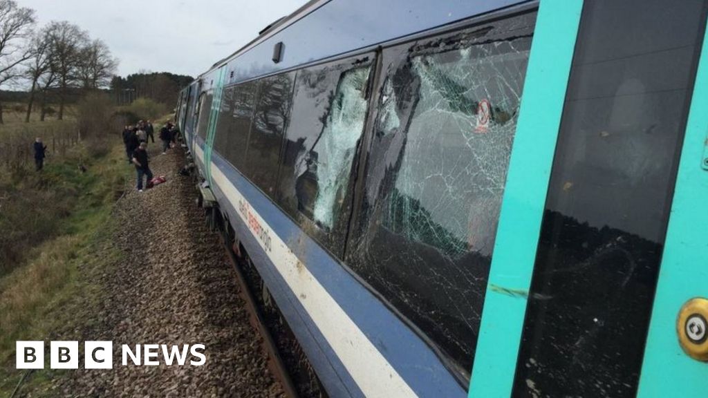 Man injured as train hits tractor at level crossing - BBC News