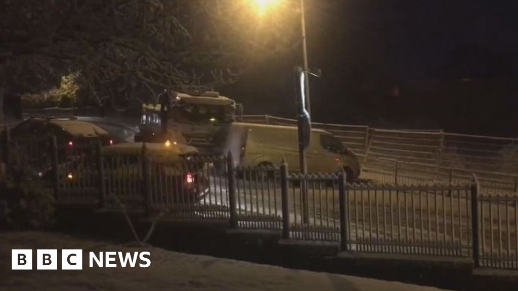 Fence stops runaway lorry as it ploughs down icy street - BBC News