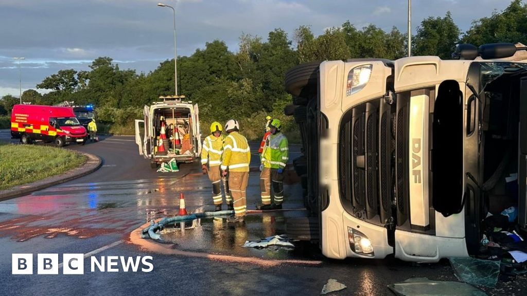 M40: Lorry carrying water tips over blocking slip road - BBC News