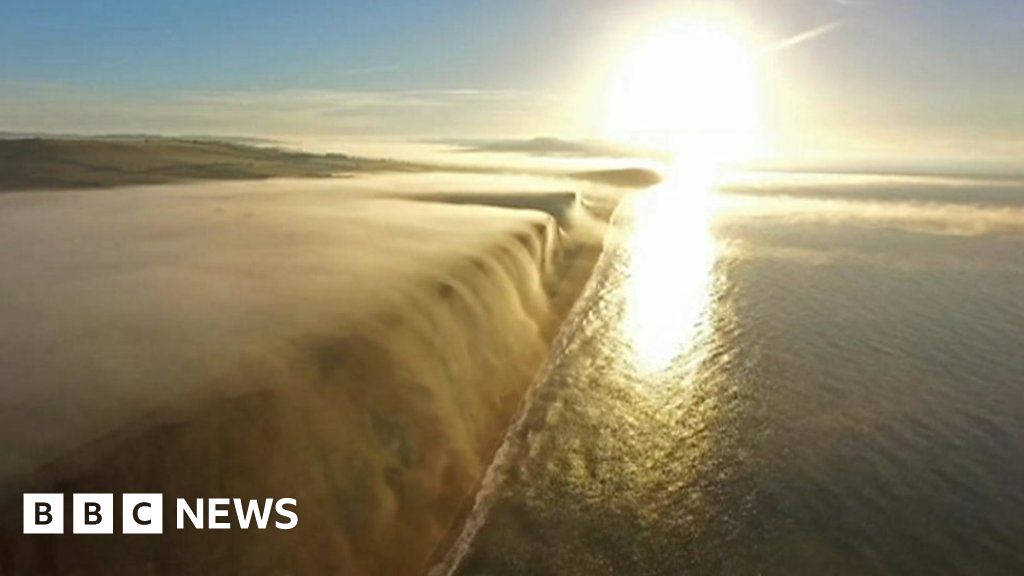 Morning mist rolls off cliffs - BBC News