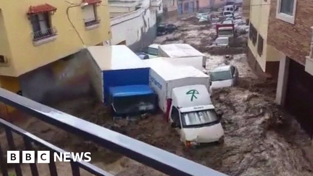 Flash floods sweep vehicles along Spanish street - BBC News