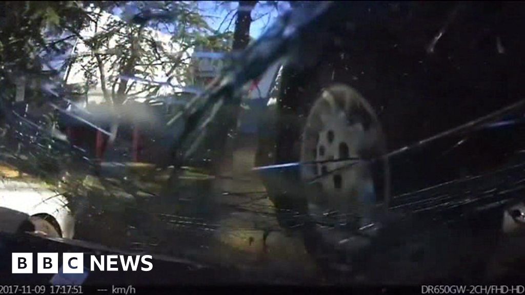 Driver hits and 'flies' over parked car in dramatic crash - BBC News
