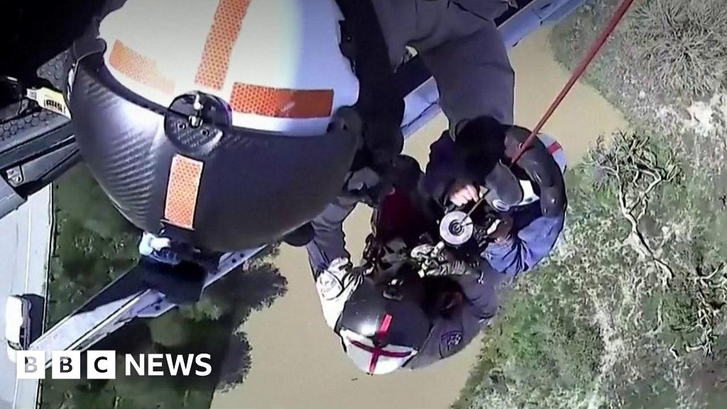 Helicopter crew rescues stranded man from flooded island - BBC News