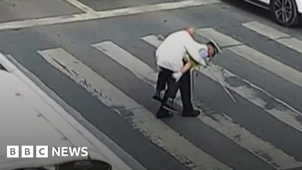 Police officer piggybacks man across busy road - BBC News