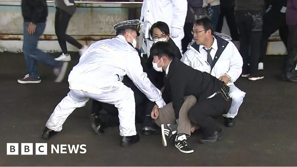 Video appears to show police pile on Japan smoke-bomb suspect - BBC News