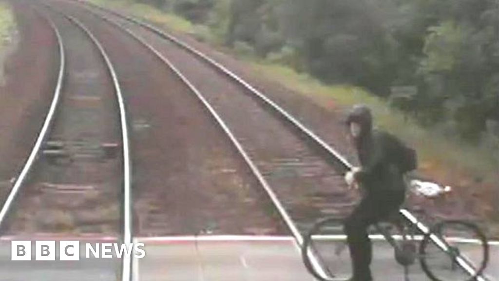 Cyclist's level crossing near-miss caught on CCTV - BBC News