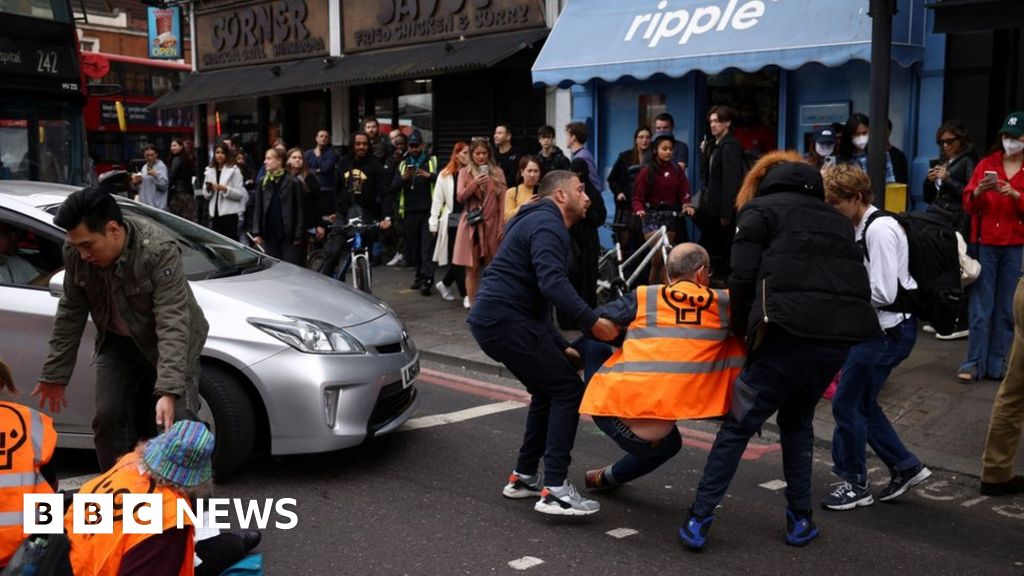 More than 20 arrested after activists glue themselves to road More than 20 arrested after activists glue themselves to road