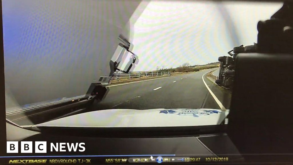 Dashcam footage shows lorry toppling onto police car - BBC News