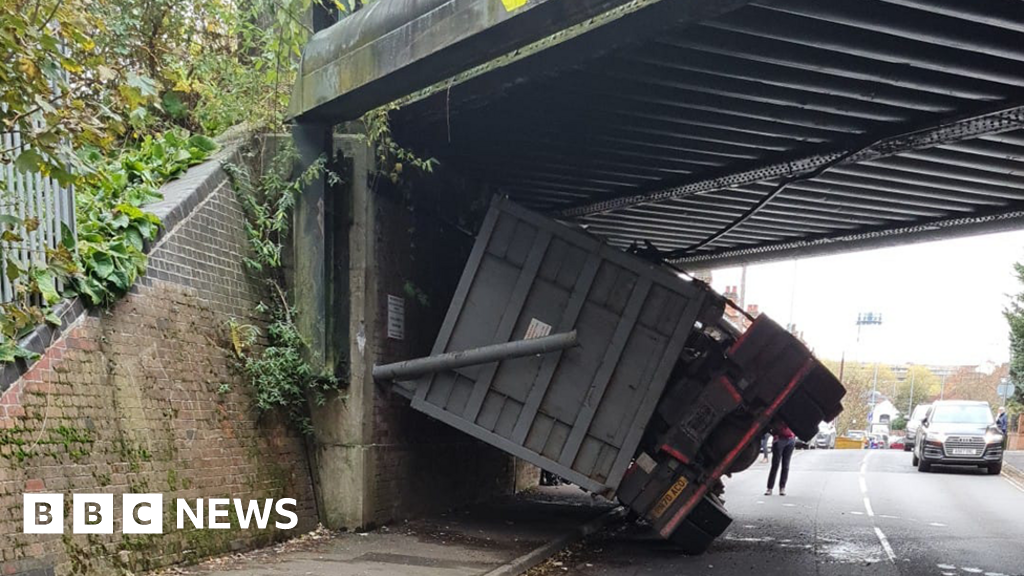 Lorry wedged under Warwick railway bridge after crash - BBC News