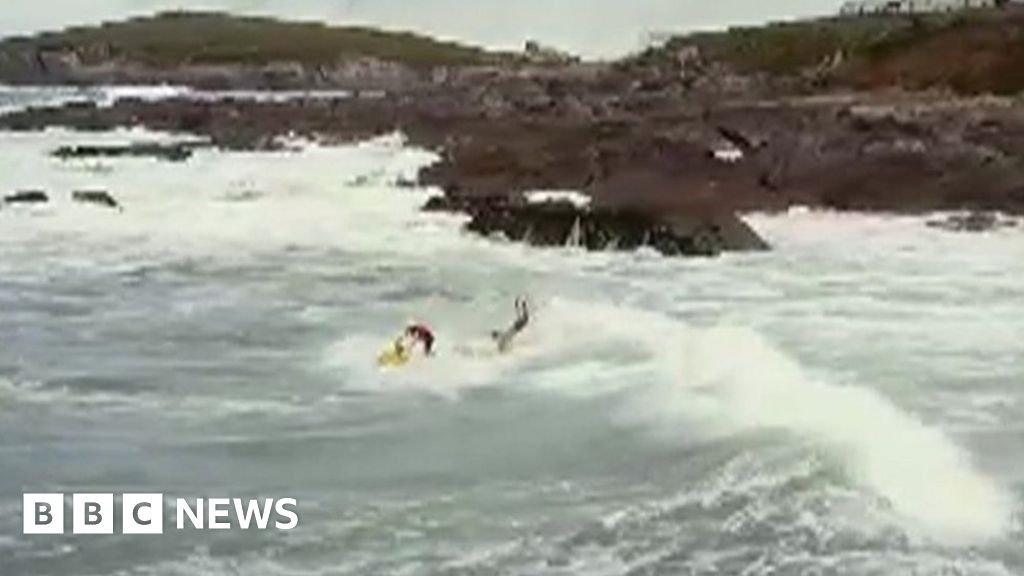Surfer rescued after longboard leash snaps in "wild" conditions - BBC News