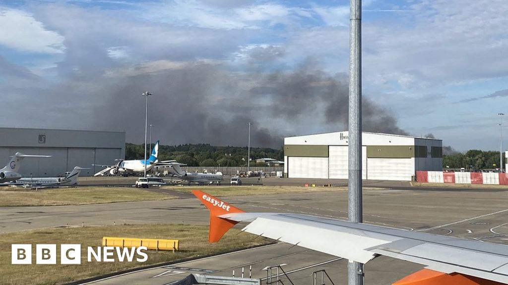 Fire crews tackle field fire close to London Luton Airport - BBC News