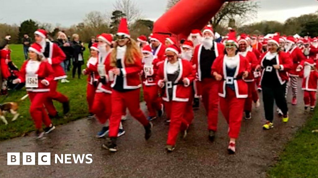 Watch: Hundreds of Santas attend fun run - BBC News