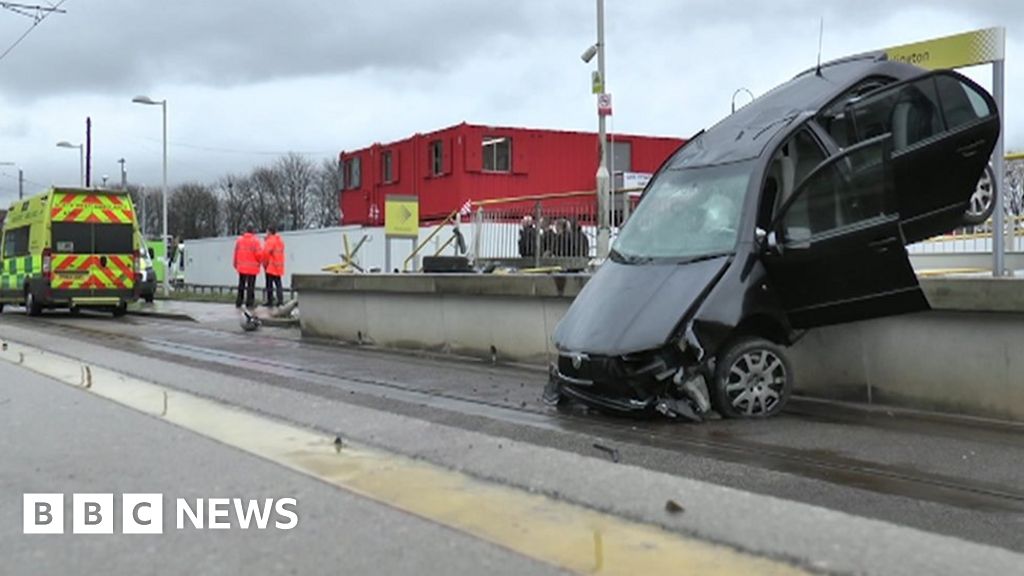 Car careers over tram platform after police chase in Manchester - BBC News