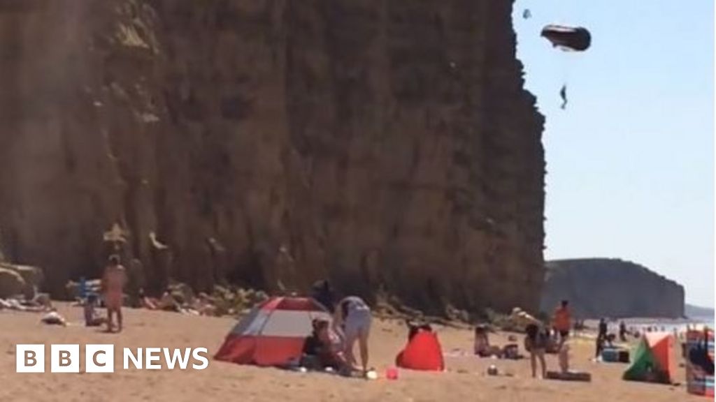Beachgoers in Dorset watch base jumpers leap off cliff - BBC News