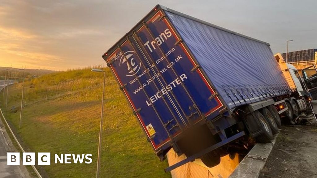 M1 crash leaves lorry hanging off bridge - BBC News