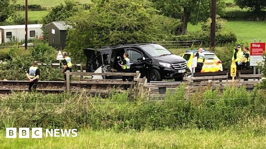Person seriously injured as train hits van at level crossing - BBC News