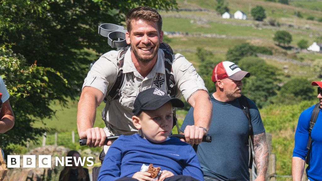 Former rugby player climbs mountain with boy with rare condition - BBC News
