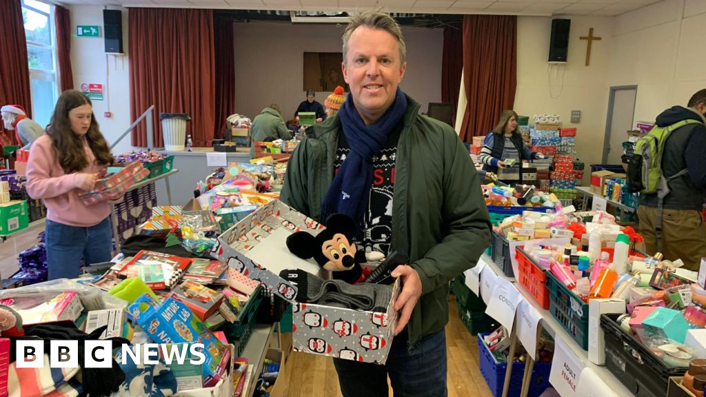 Ex-cricketer Graeme Swann helps pack Christmas shoebox gifts