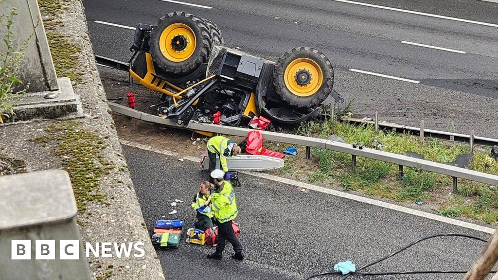 Tractor falls off bridge on to M20 leaving man in hospital