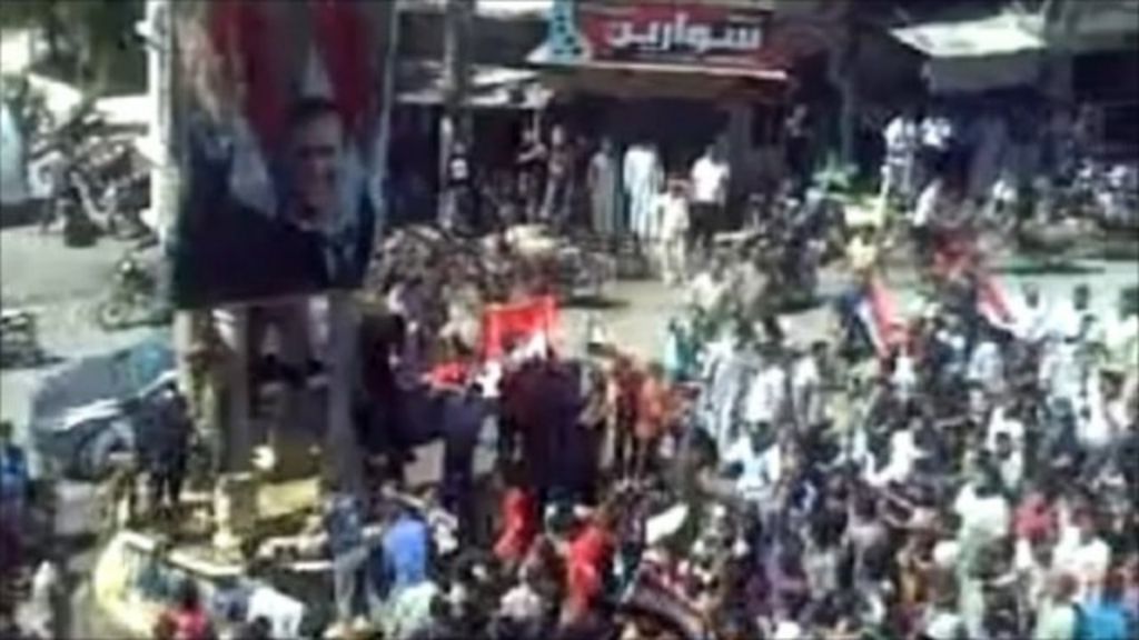 Protesters attack photos of Assad - BBC News