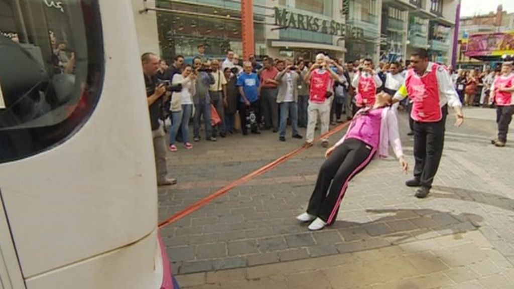 Record attempt to pull double decker bus with just hair - BBC News