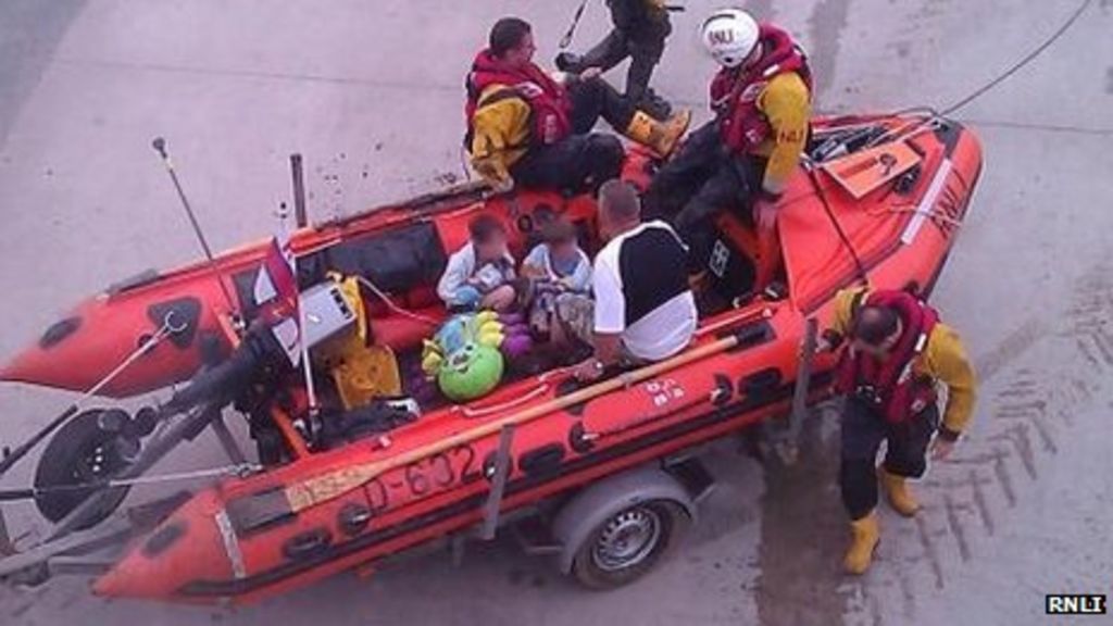 Three in mud rescue near Rhyl harbour wall - BBC News