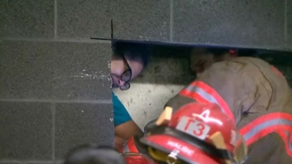 Woman trapped in tiny gap between building walls - BBC News