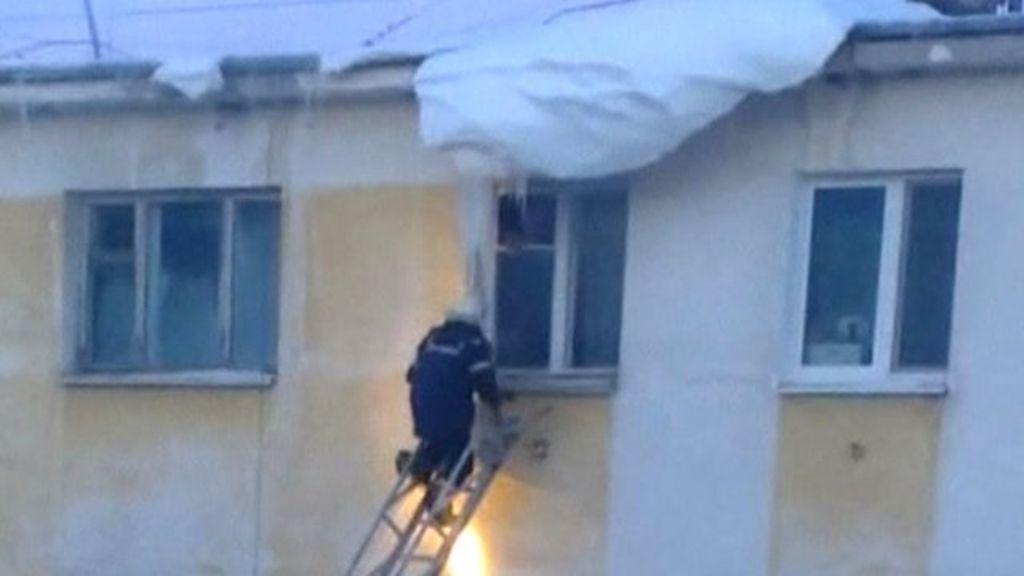 Fireman knocked off ladder during rescue bid in Russia - BBC News