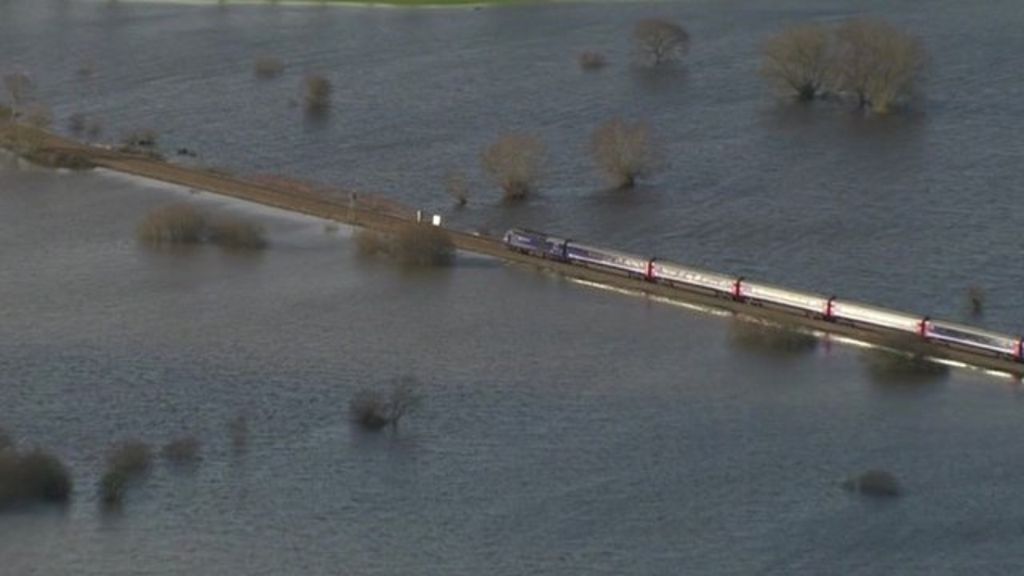 UK storms: Aerial pictures of train travelling through floods - BBC News