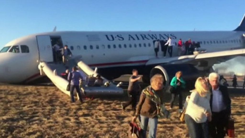 Passengers leave plane on slides after landing gear collapse - BBC News