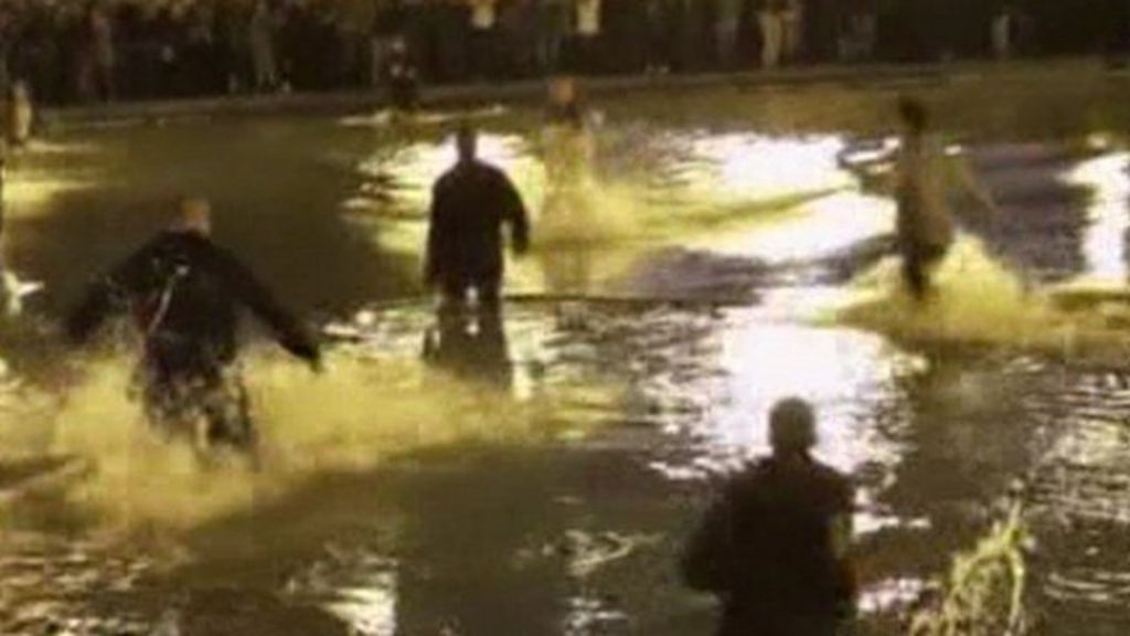 Kanye West mobbed after jumping in lake during gig - BBC News