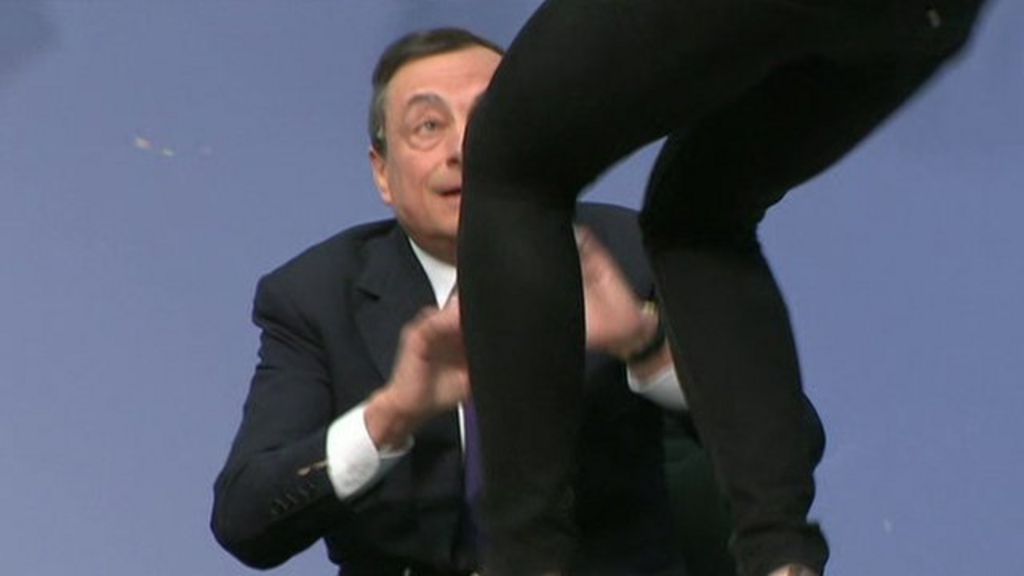 Protester jumps on Draghi desk at news conference - BBC News Protester jumps on Draghi desk at news conference - BBC News
