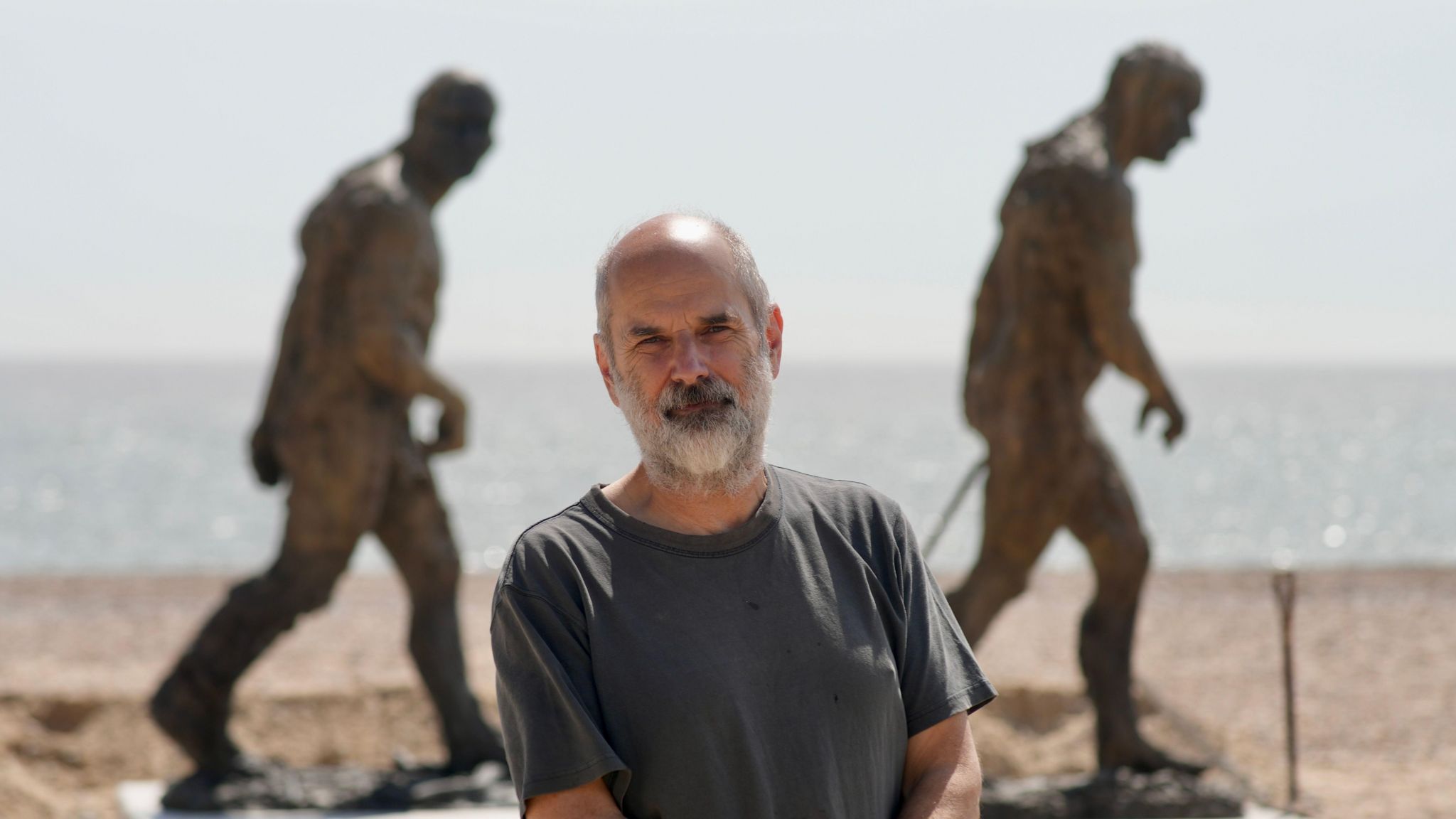 Lowestoft beach welcomes giant sculpture of five walking men - BBC News