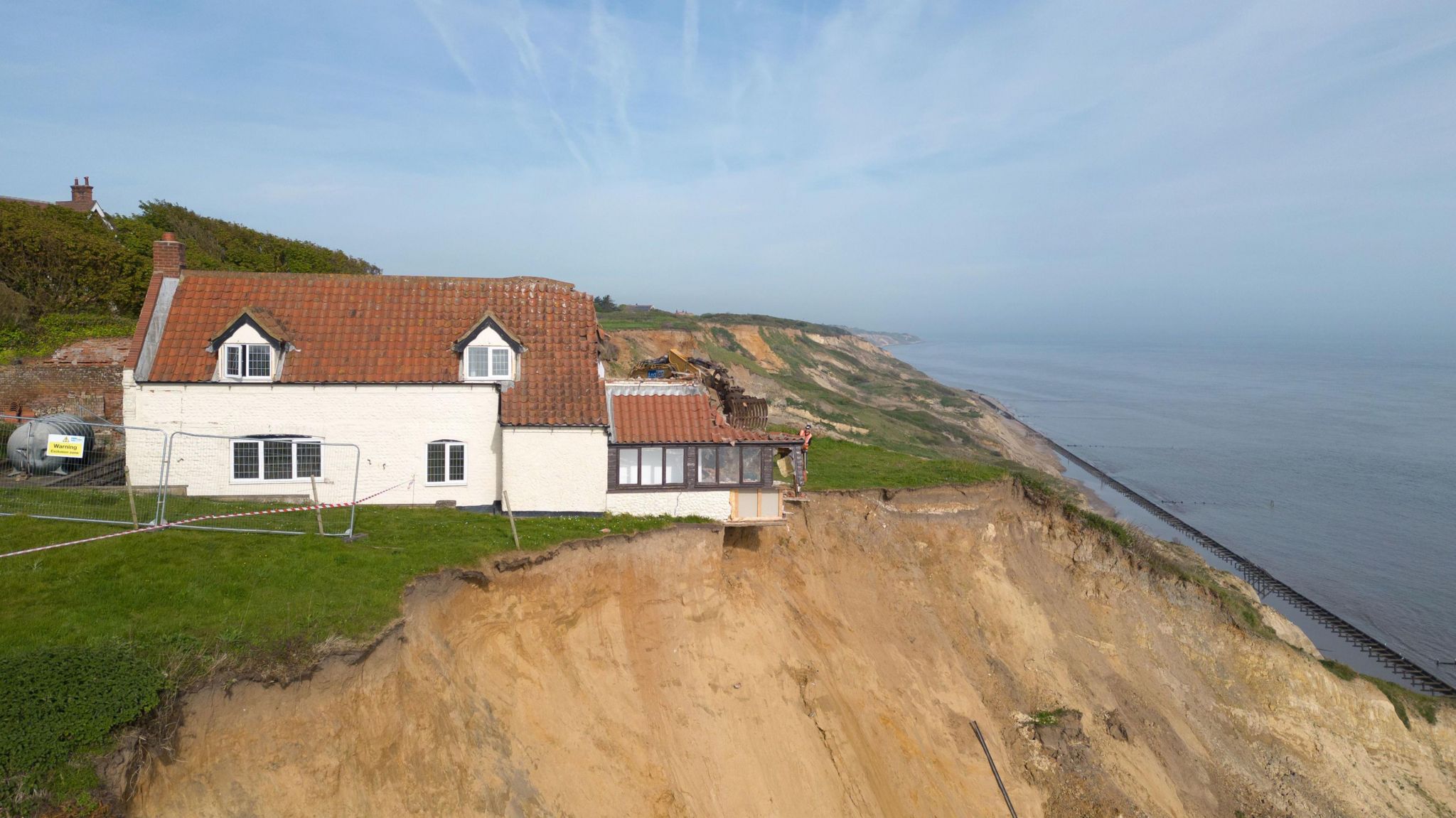 Trimingham farmhouse teetering over cliff edge demolished - BBC News