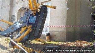 Two tree surgeons hurt as cherry picker falls over - BBC News