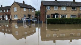 Wales flooding: Driver rescued and homes evacuated - BBC News