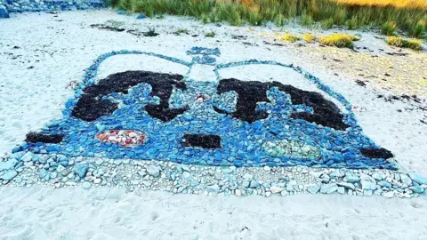 Giant crown beach art pays tribute to the Queen
