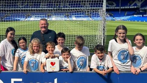 Defibrillator funding: Children complete record bid at Everton - BBC News