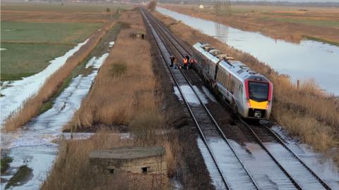 Rail passengers led to safety as Norfolk tracks flood - BBC News
