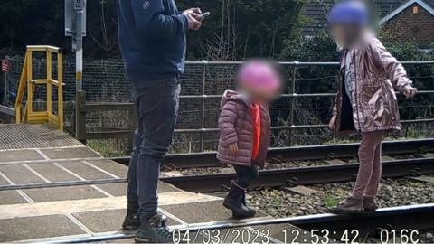 Trespassers pose for photo on Calcot Mill level crossing - BBC News