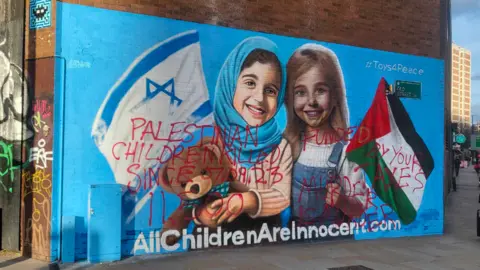 Israel-Gaza: Defaced peace mural is painted black by TfL
