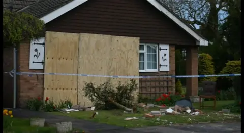 Two hurt when car hits house in Bedworth before being driven away