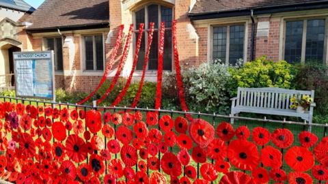 Wellesbourne Remembrance cascade of poppies knitted by villagers - BBC News