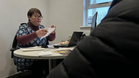 Facing never-ending queues on the debt front line - BBC News