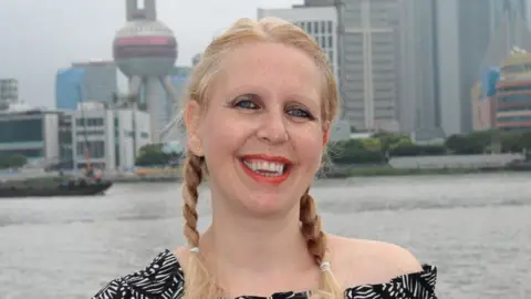 Coma teacher's partner fears she will not be able to get home